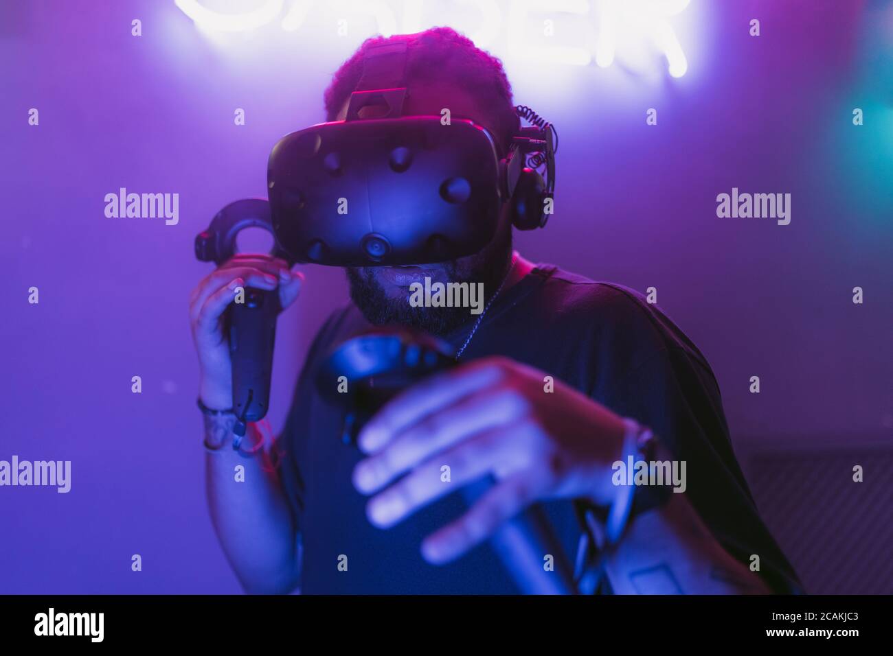 The guy is playing VR games. Neon blue light Stock Photo - Alamy