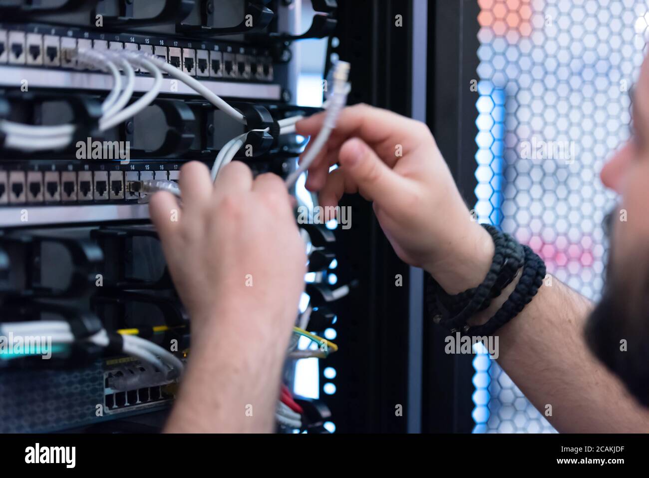 An Expert Engeneer in datacenter server room connecting cables in ...