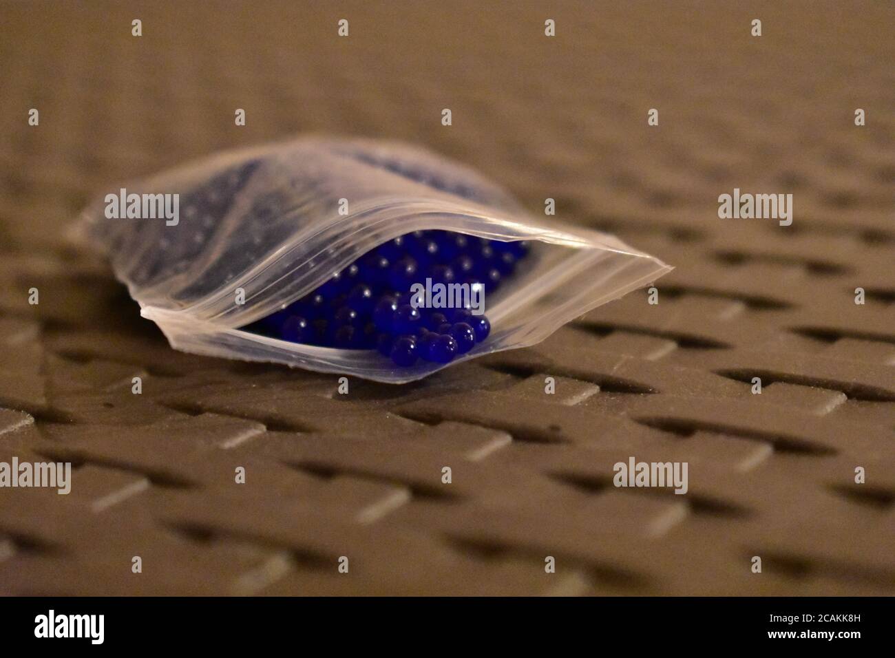 Tiny Blue Orbs in a Plastic Pouch on a Lattice Table Stock Photo - Alamy