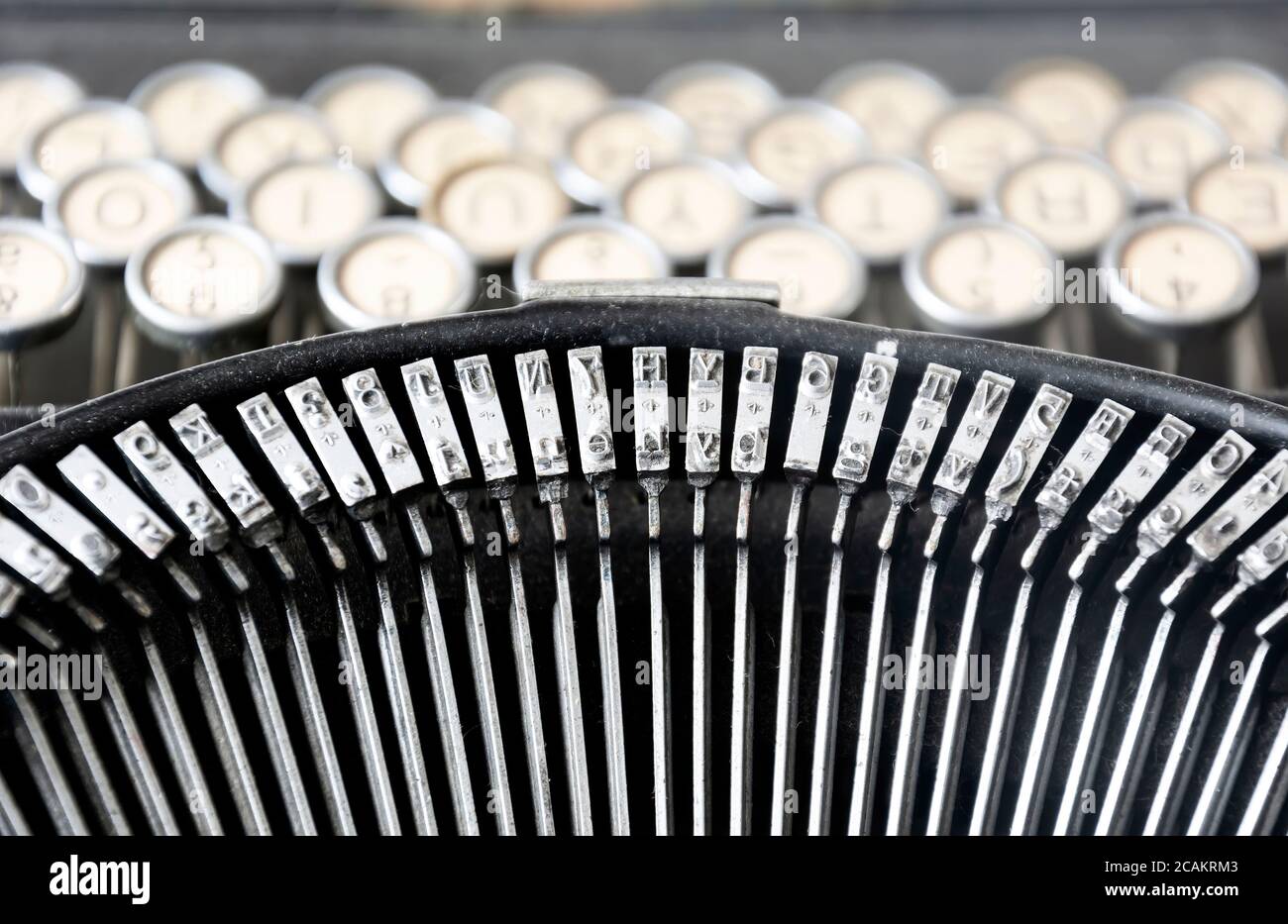 the iron hammers of an old typewriter with the keys blurred in the ...