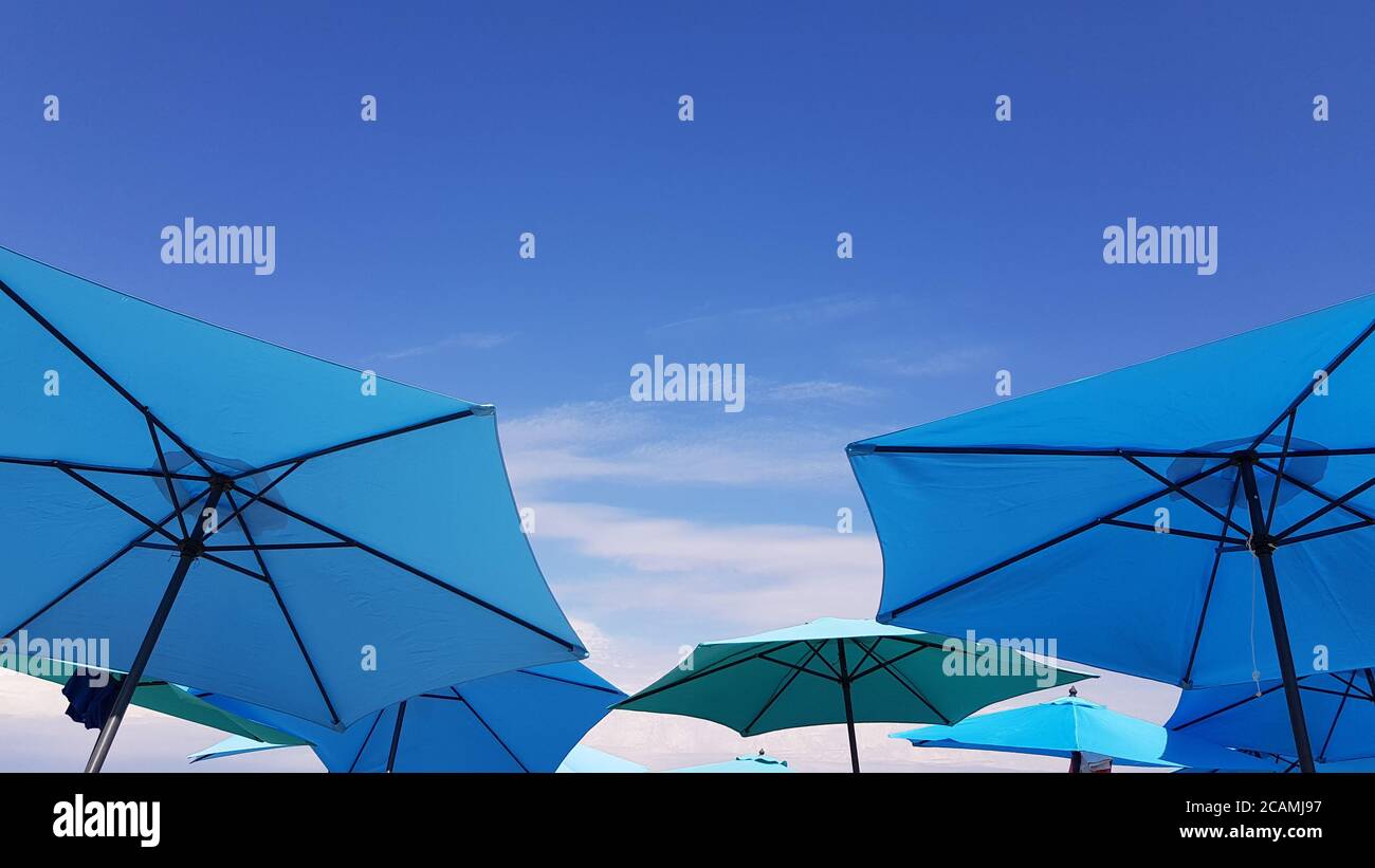 Bright blue and turquoise color parasols on blue sky backgrounds with ...
