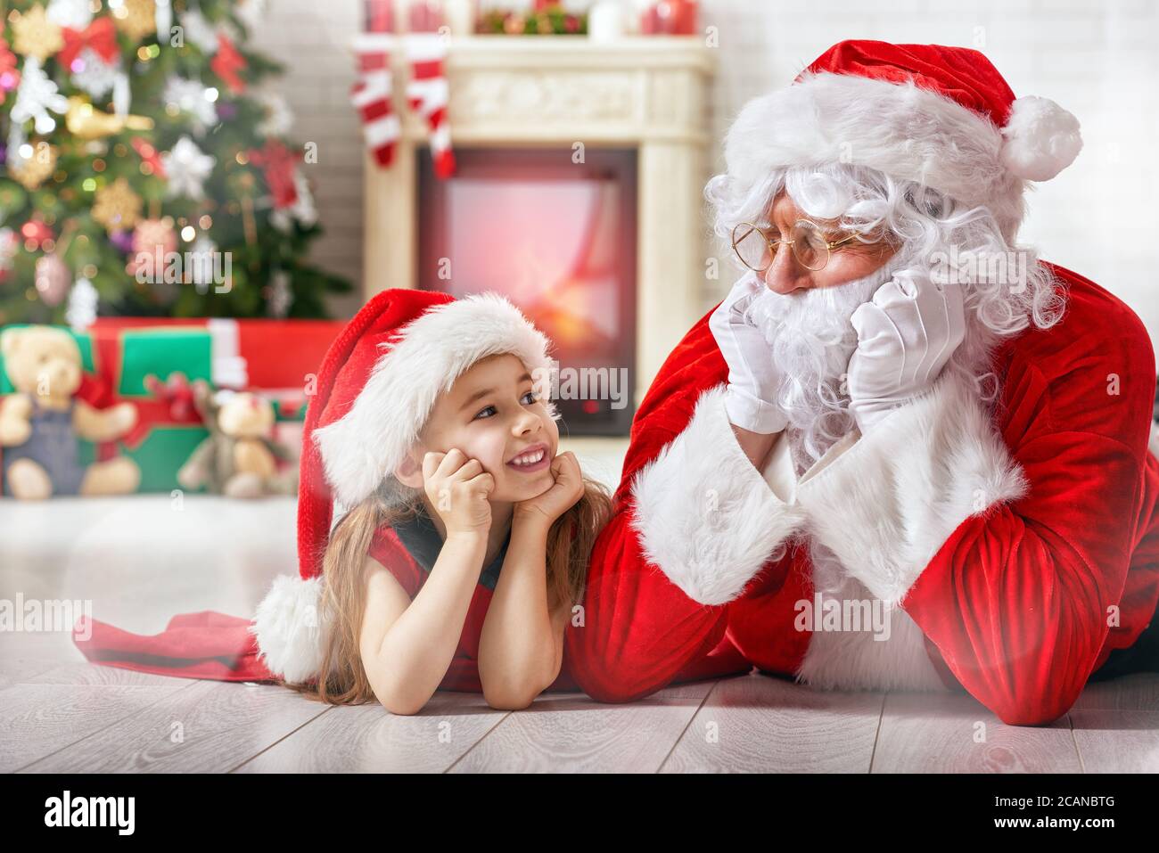 Santa Claus and cute girl getting ready for Christmas Stock Photo - Alamy