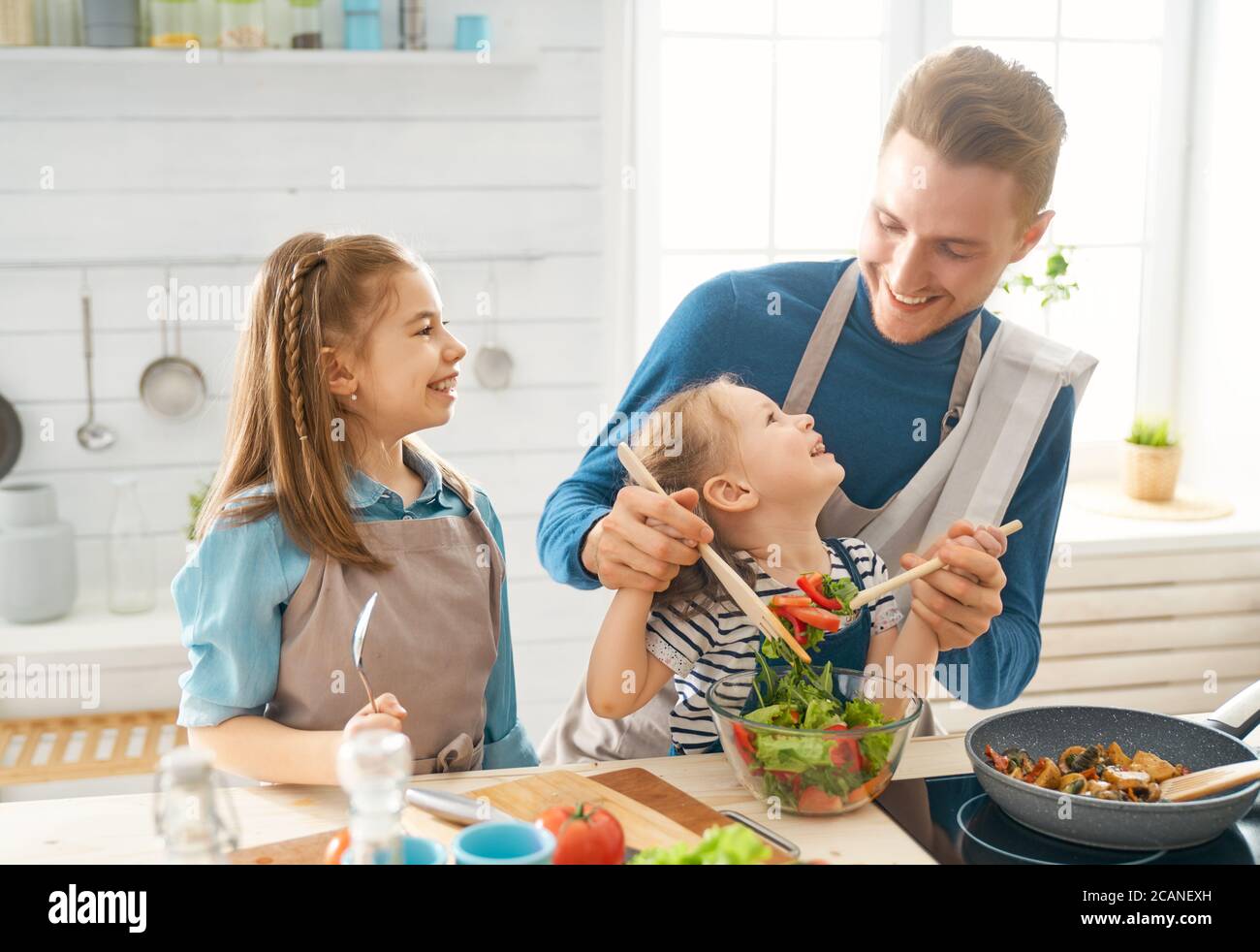 Healthy food at home. Happy family in the kitchen. Father and children ...