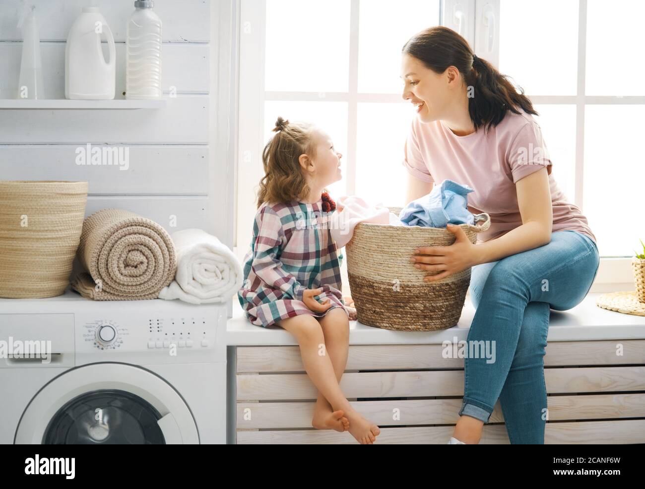 Beautiful young woman and child girl little helper are having fun and ...