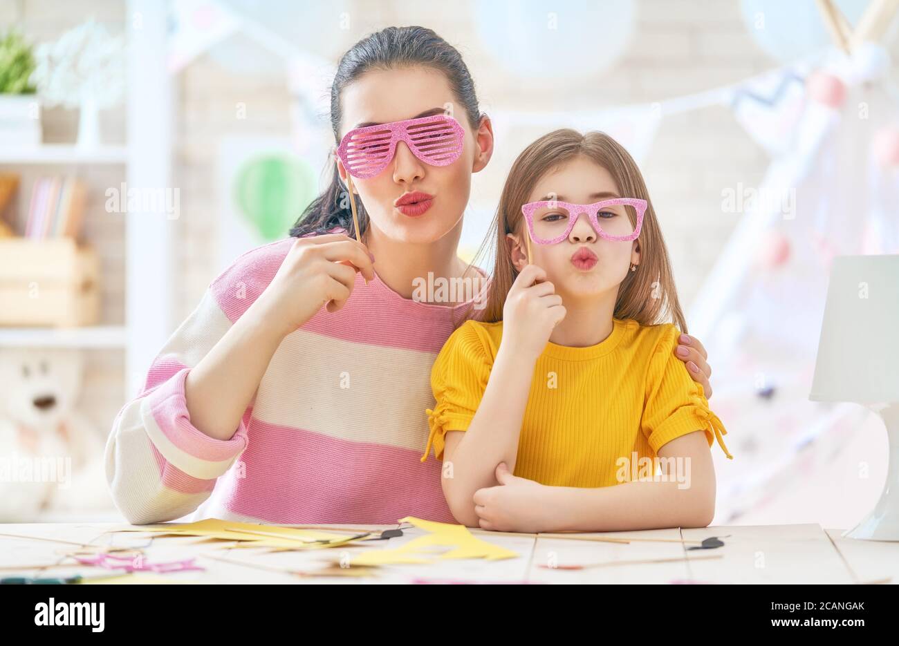 Funny family! Mother and her child daughter girl with a paper ...