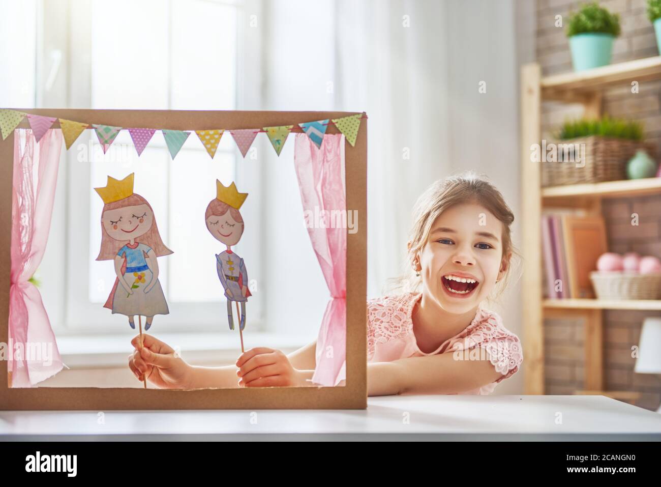 Happy girl plays with performance in the puppet theater with prince and ...