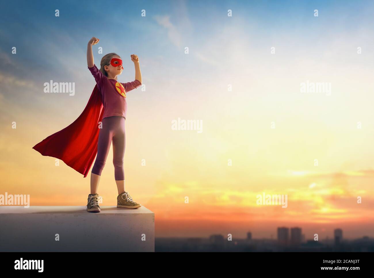 Little child playing superhero. Kid on the background of sunset sky ...