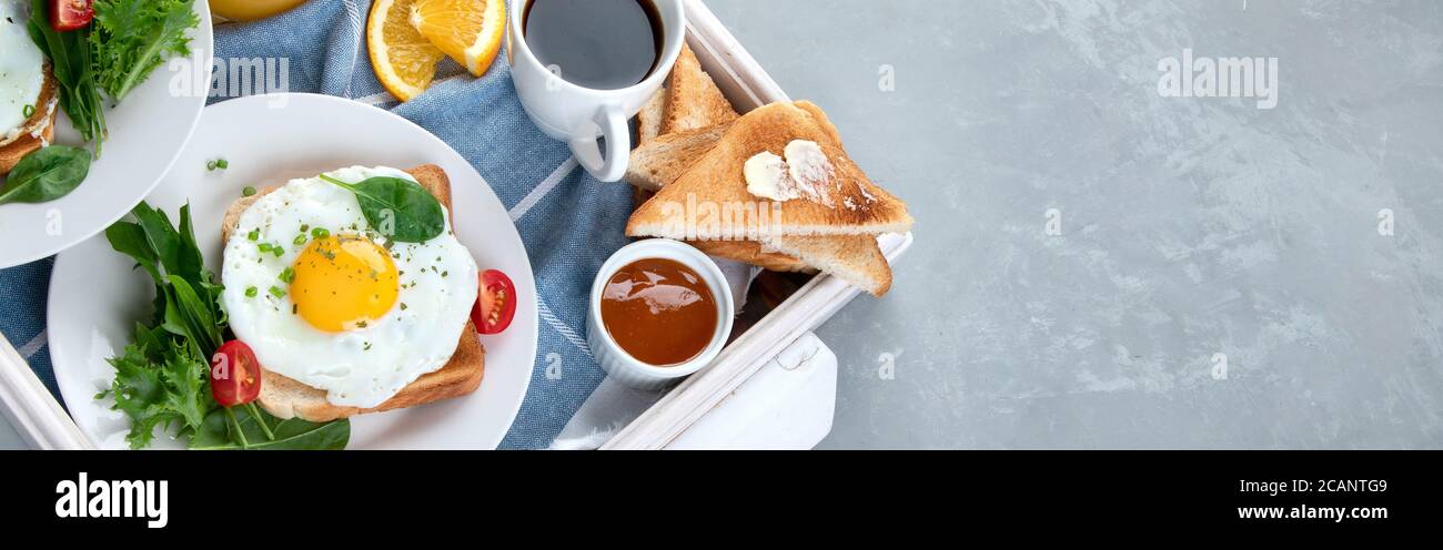 Traditional American breakfast served in white wooden tray on grey ...