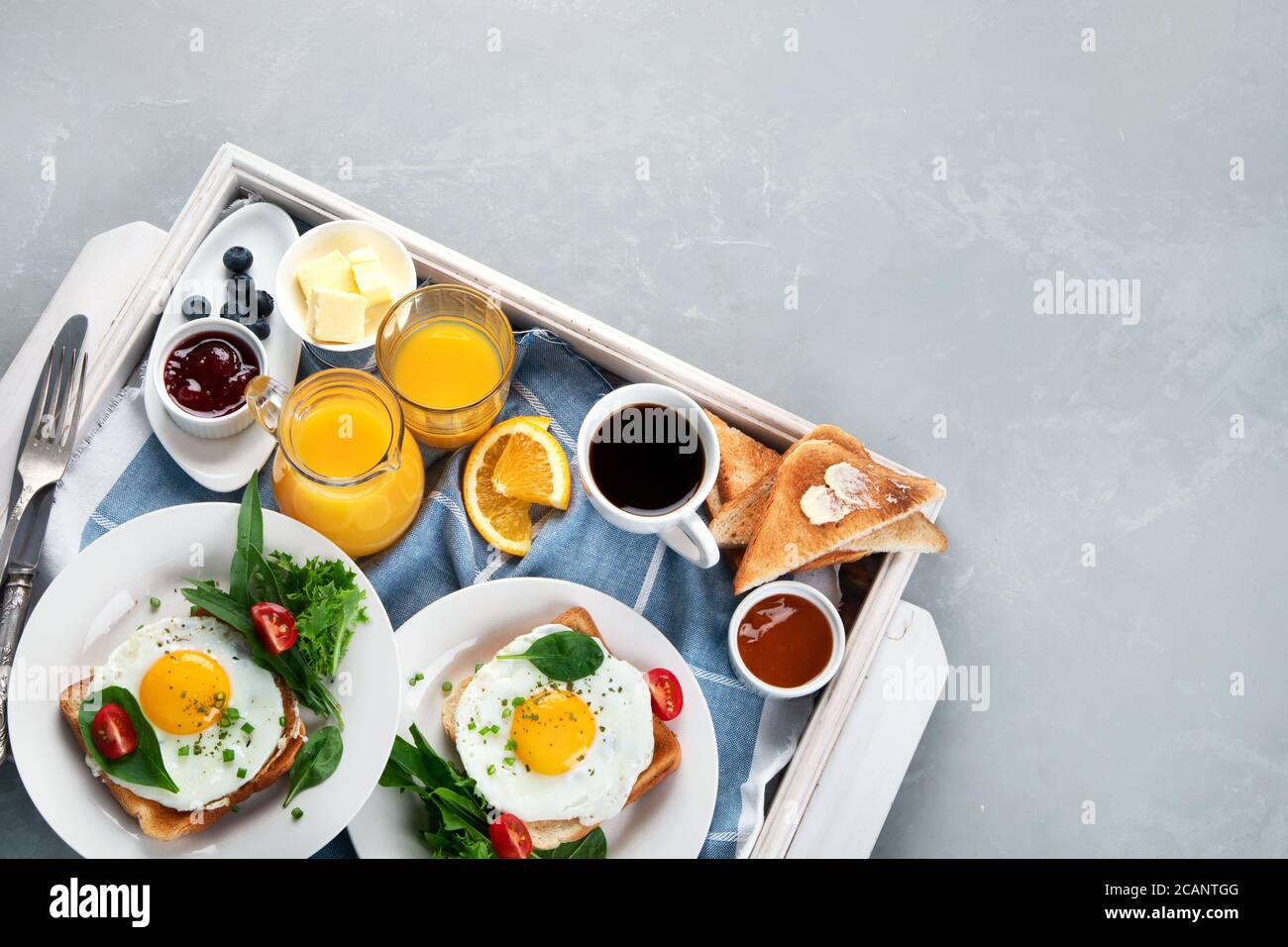Traditional American breakfast served in white wooden tray on grey ...