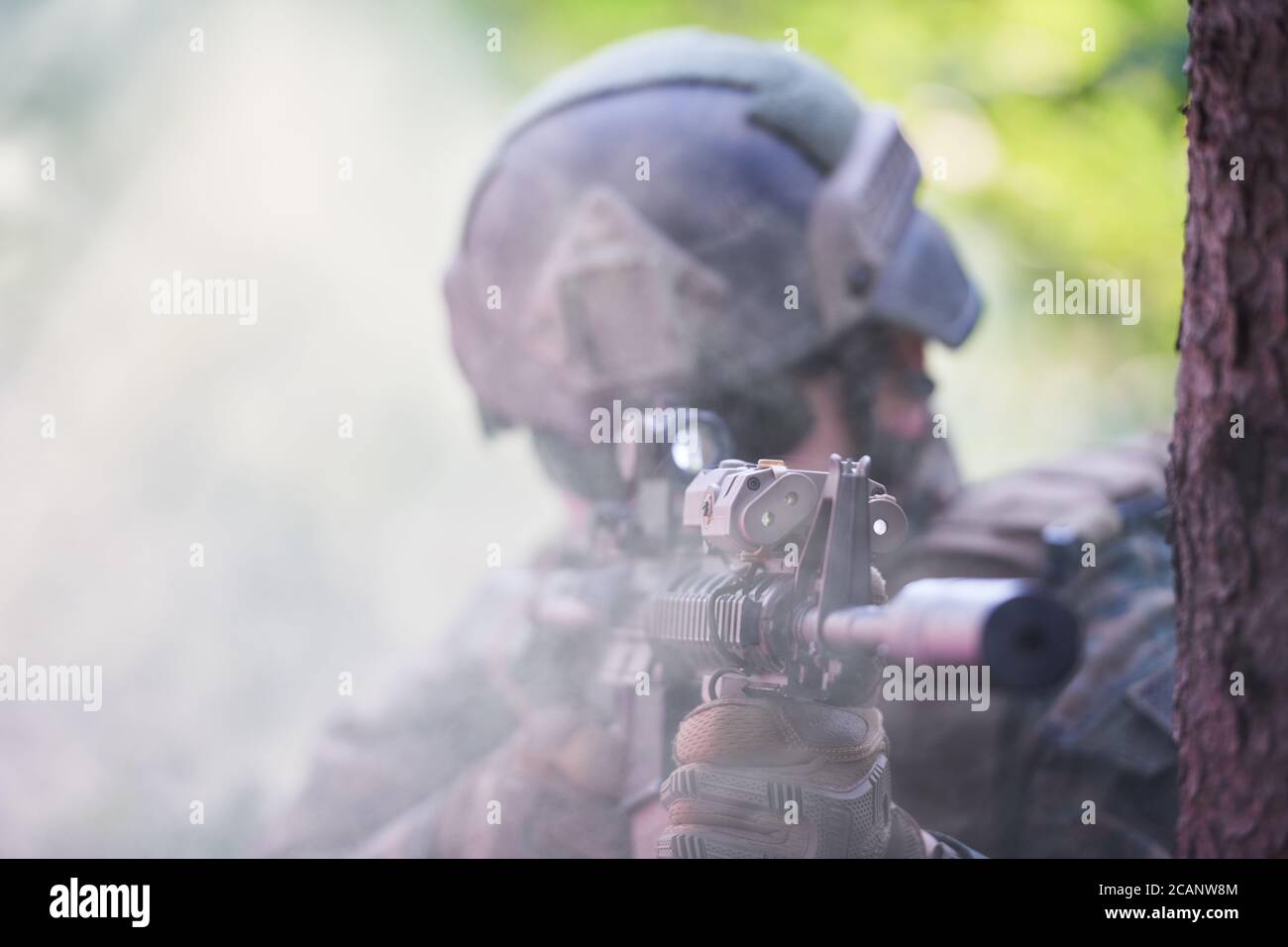modern warfare soldier in action aiming at weapon laser sight optics in ...