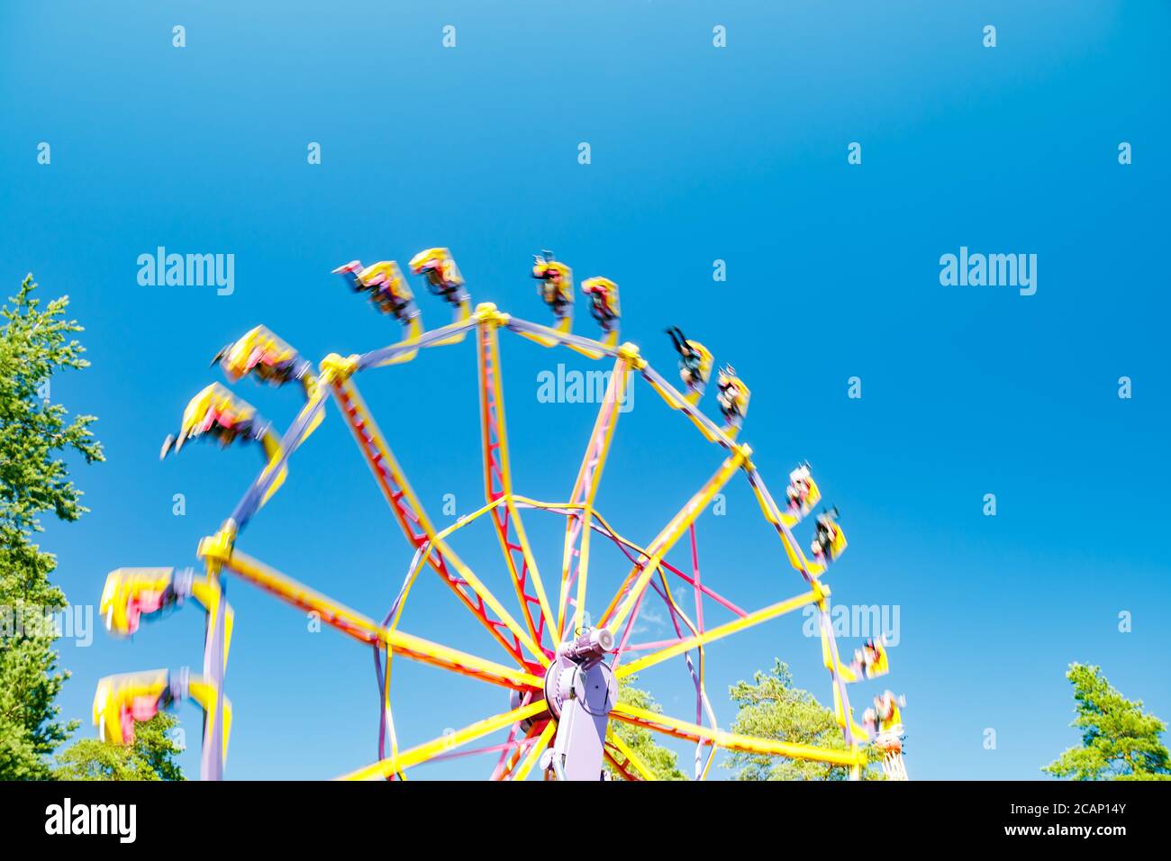 Extreme ride in motion in amusement park at sunny day Stock Photo - Alamy