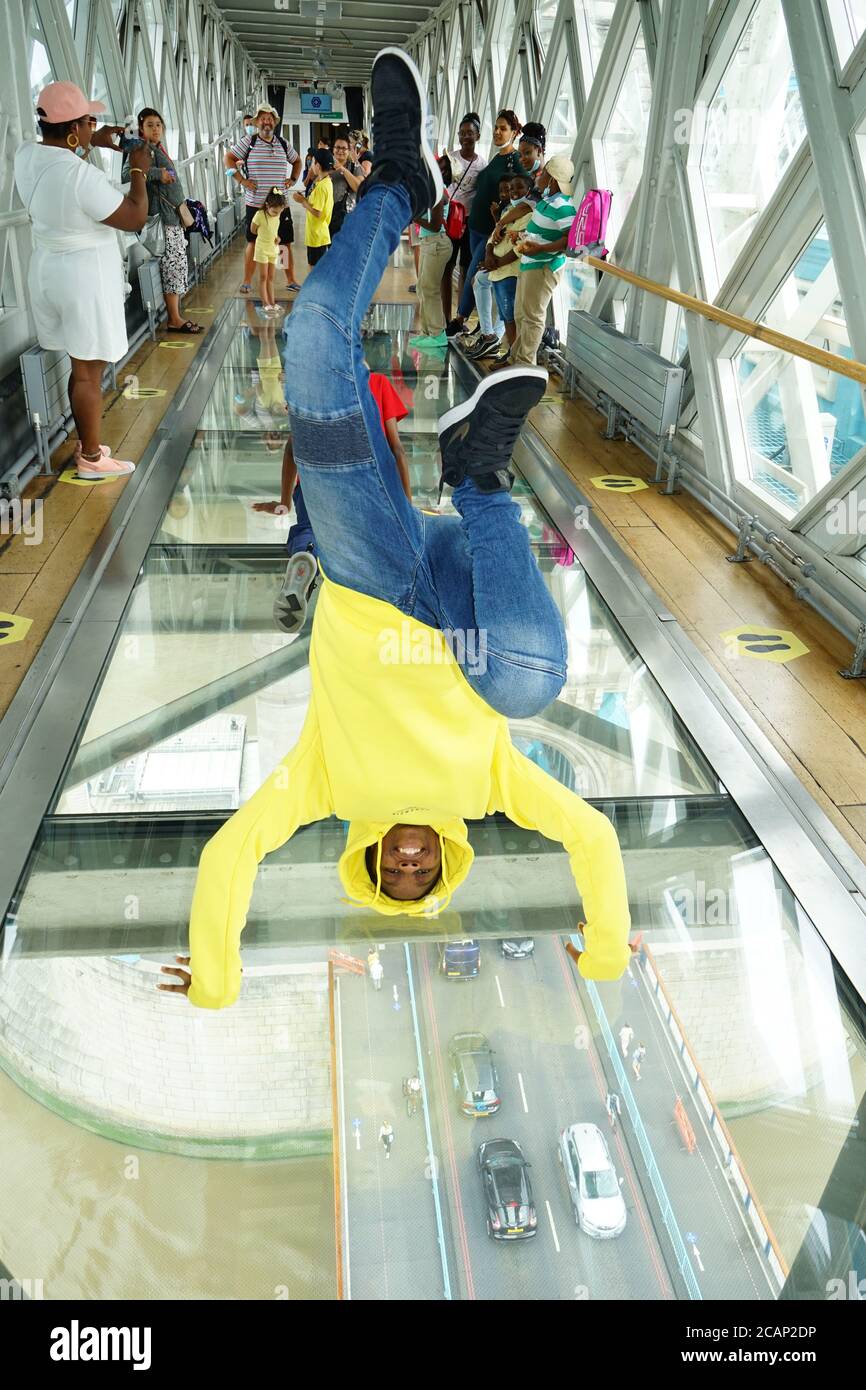 Young girl doing head stand on the glass floor of Tower Bridge London ...