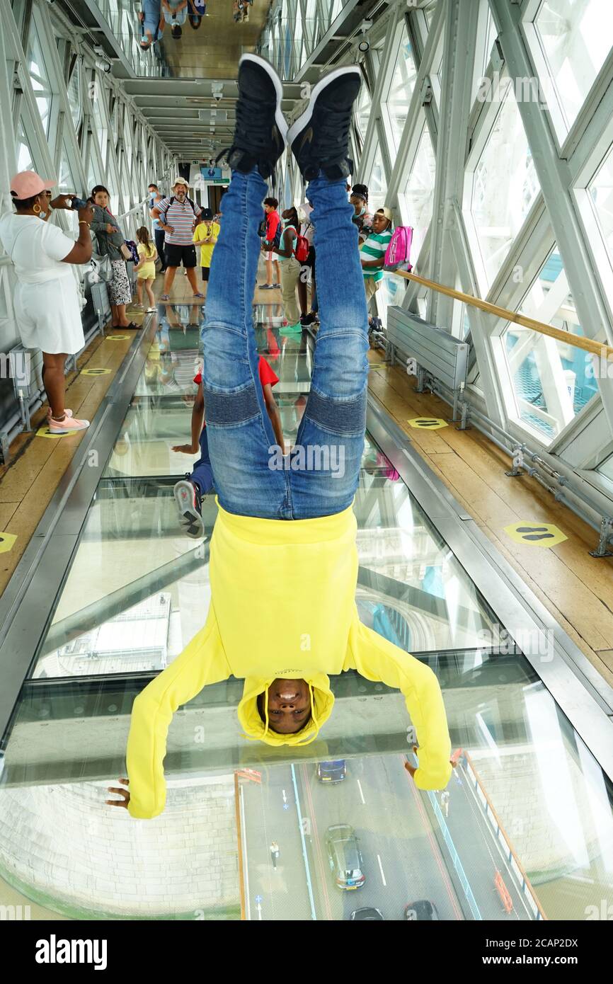 Young girl doing head stand on the glass floor of Tower Bridge London ...