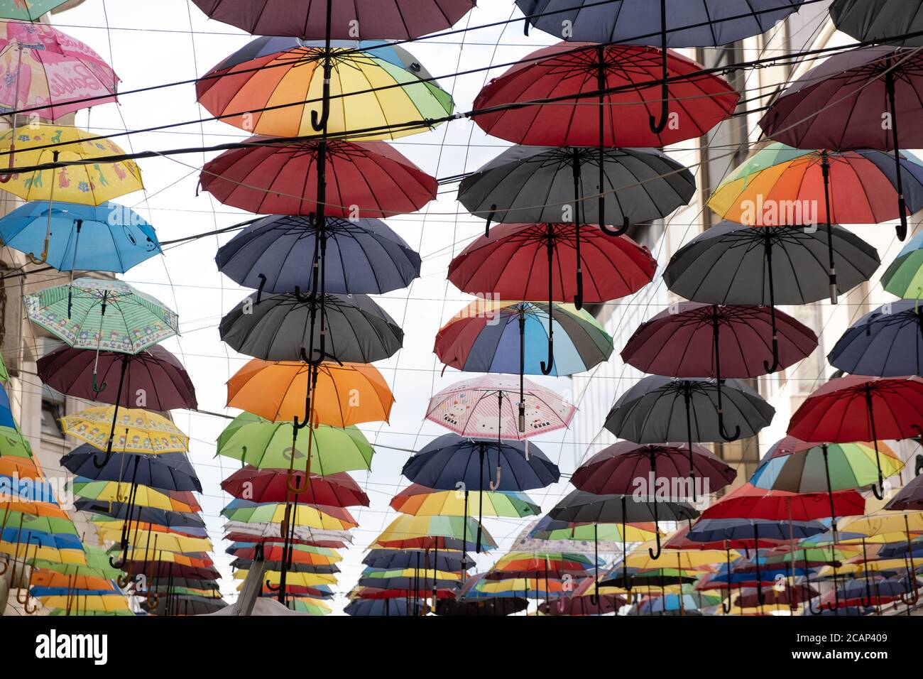 A group of different colored umbrella placed next to each other above ...
