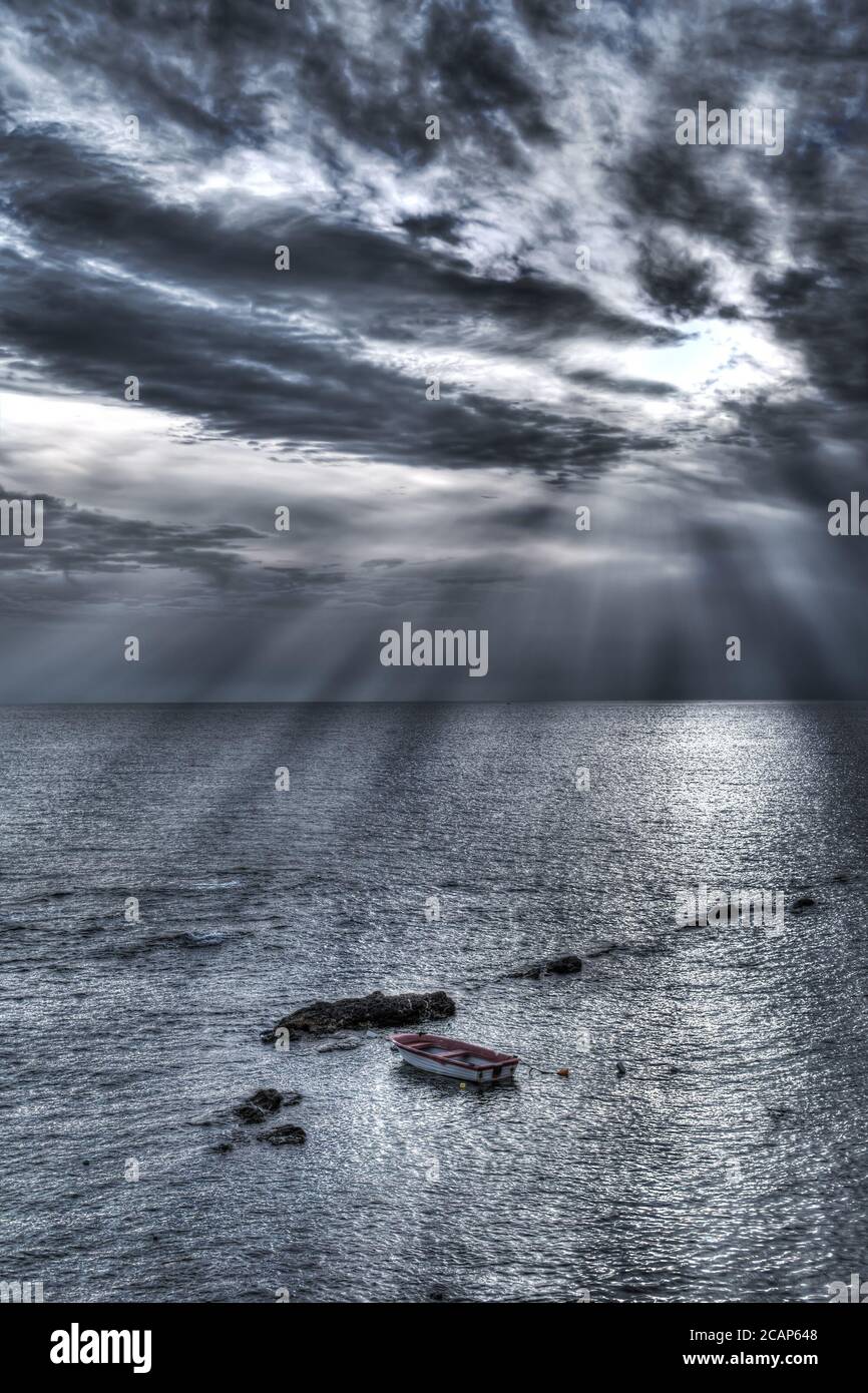 wooden boat alone in the sea under a dramatic sky Stock Photo - Alamy