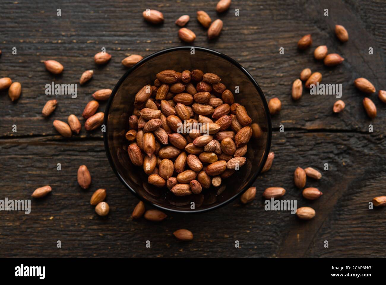 Peanut nuts in a small plate on a vintage wooden table. Peanuts nut is ...