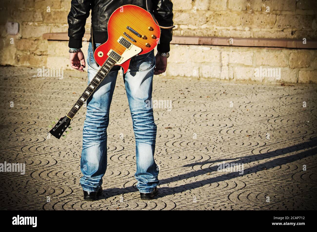 back view of a guitarist standing with a guitar. Vintage effect Stock ...