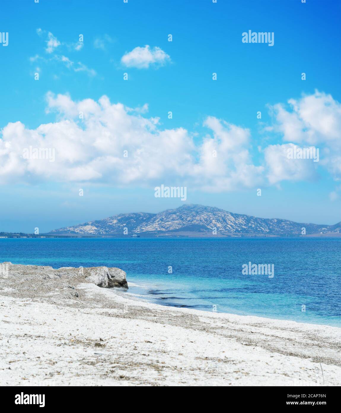 Stintino shoreline under a blue sky with clouds. Shot in Sardinia ...