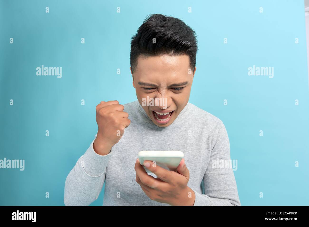 Angry man screaming on the phone isolated on a blue background Stock ...