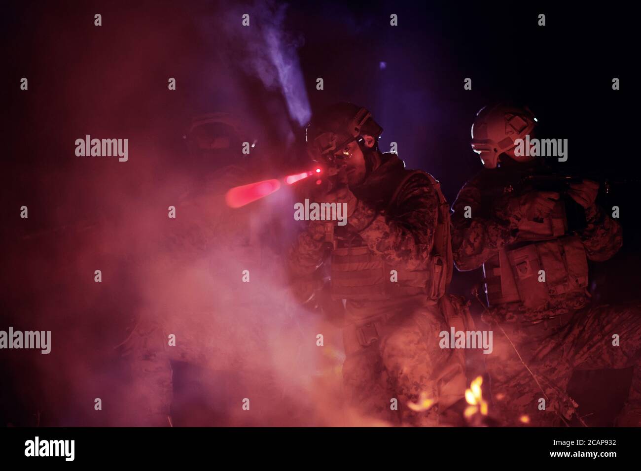 soldiers squad in action on night mission using laser sight beam lights ...