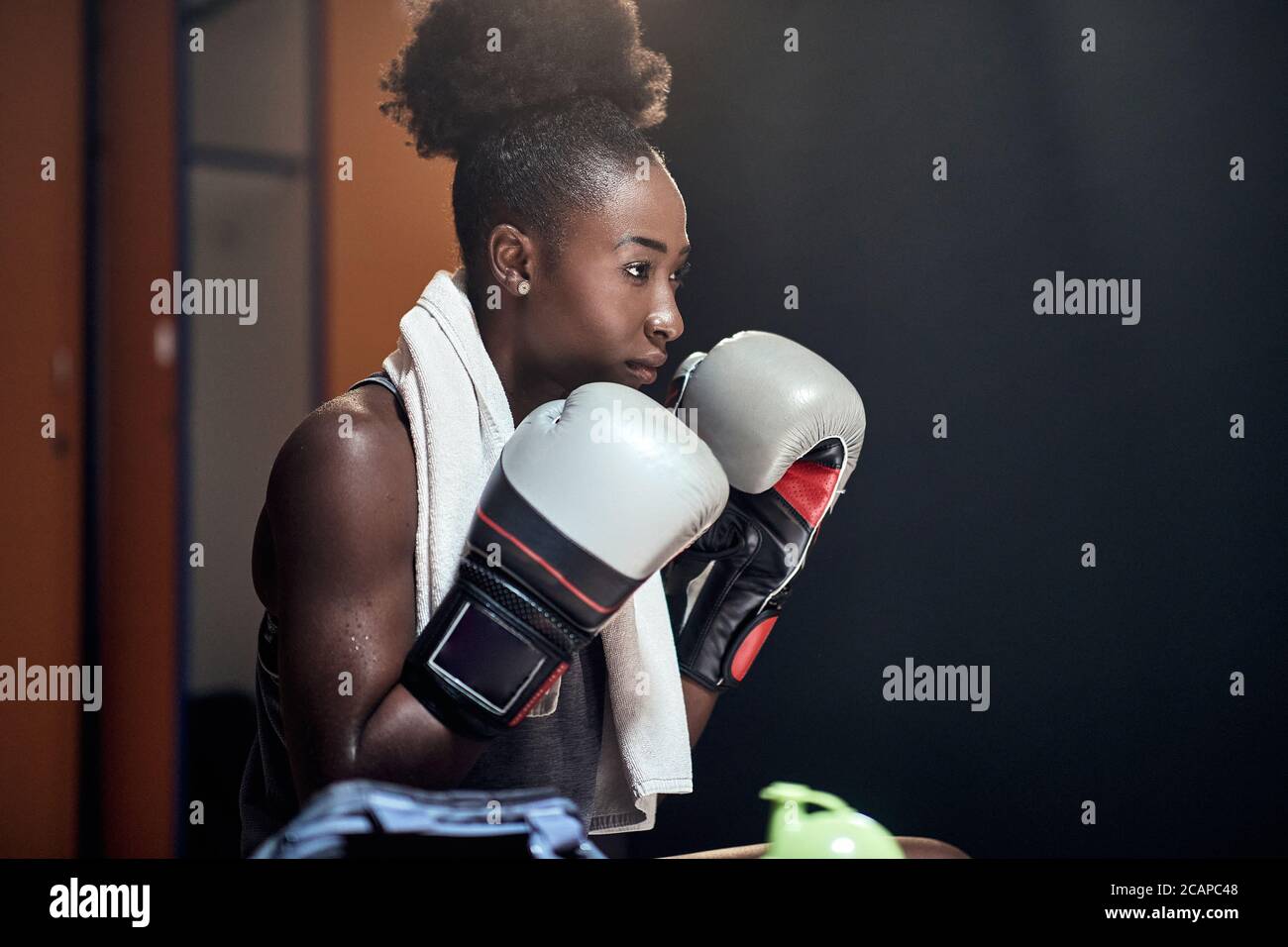 A young female boxer in a locker room focused on the match Stock Photo ...