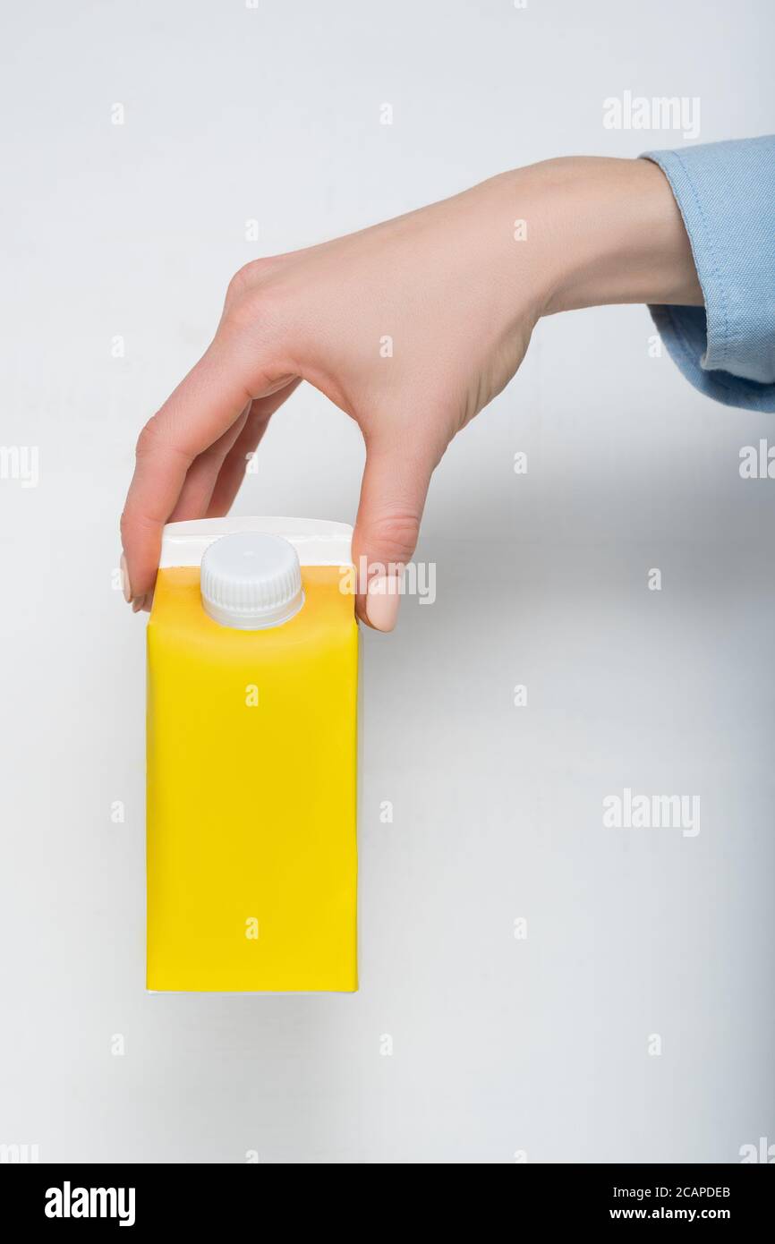 Yellow carton box with a cap in a female hand. White background Stock ...