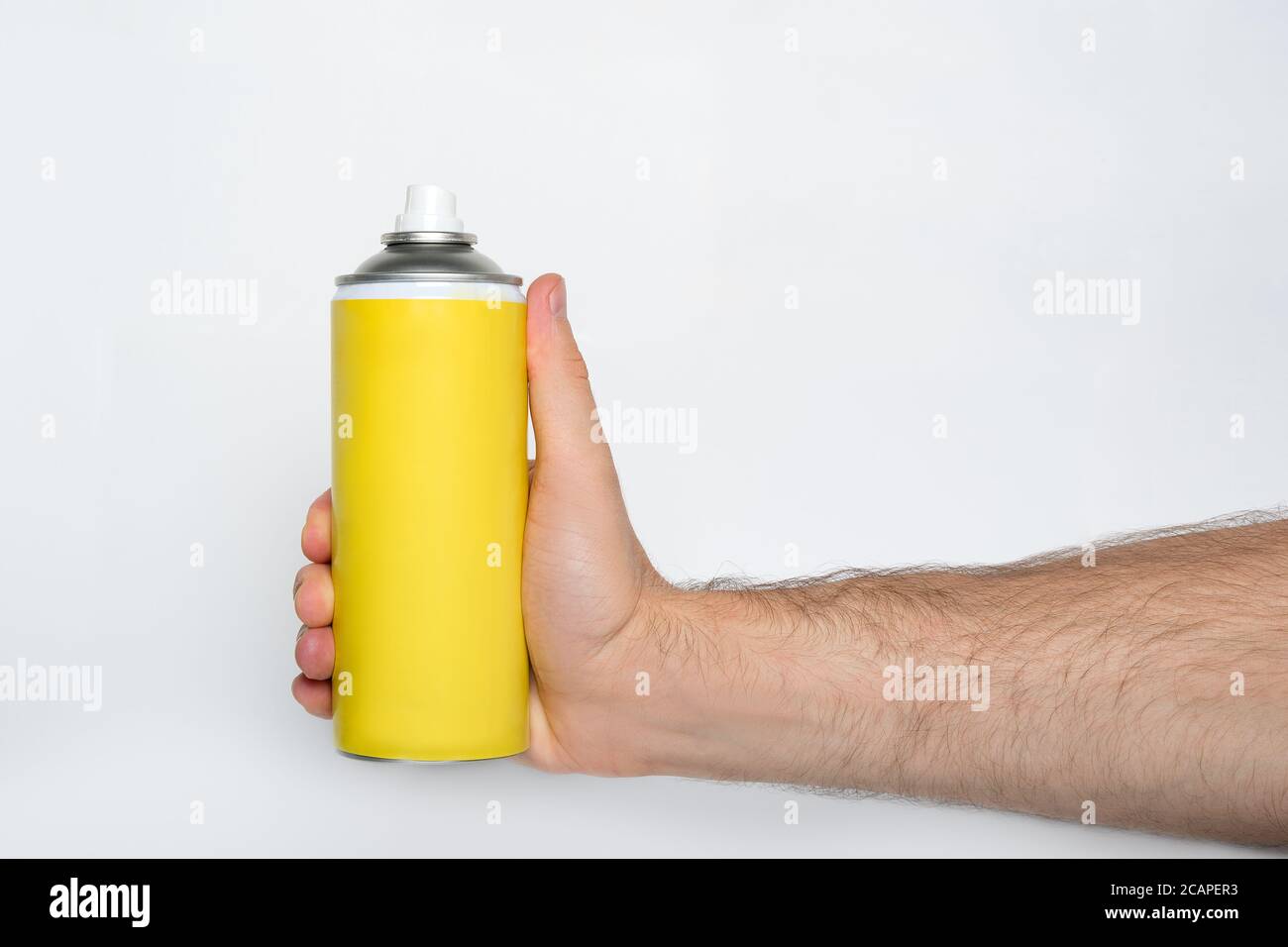 Yellow spray can for spraying in a male hand. No inscriptions. White ...