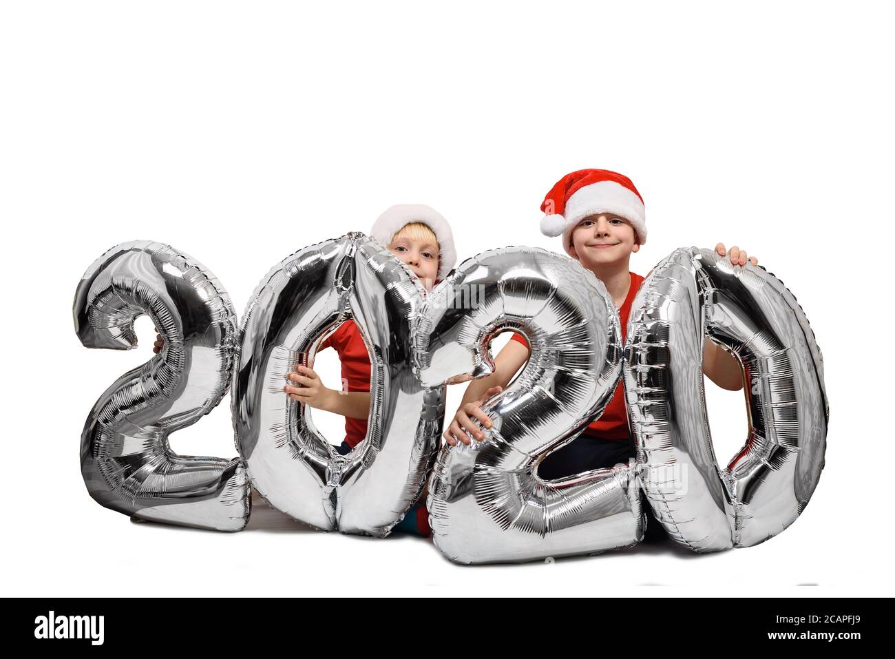 Two boys in Christmas hats are holding silver inflatable figure 2020 ...
