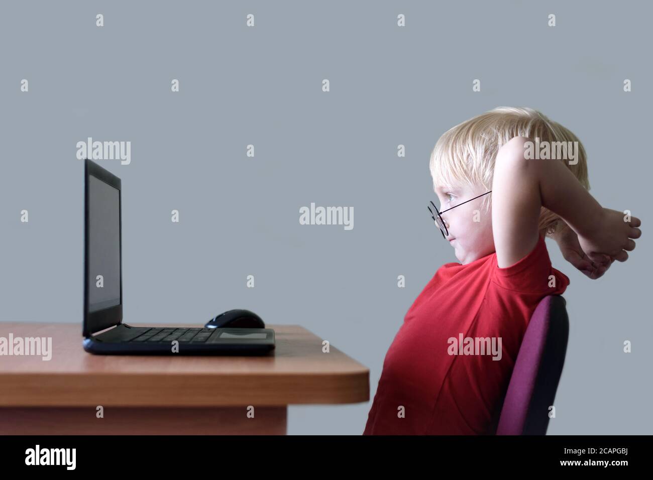 Funny blond boy in glasses resting at a laptop. Internet and ...