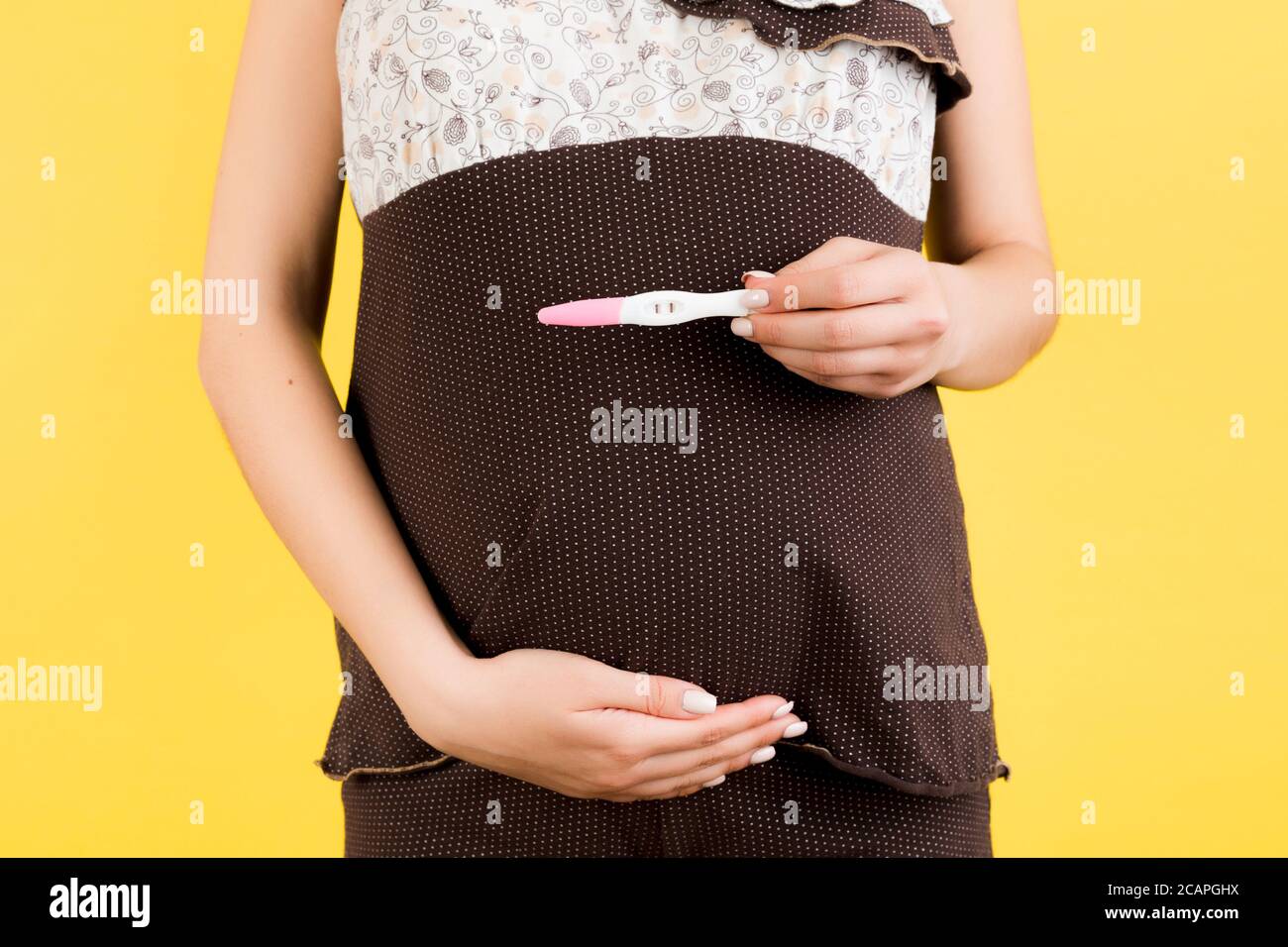 Cropped image of positive pregnancy test with two stripes against ...