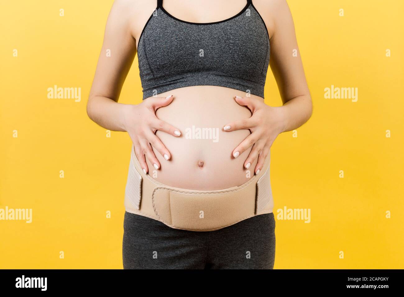 Close up of elastic maternity band dressed on pregnant woman to reduce ...