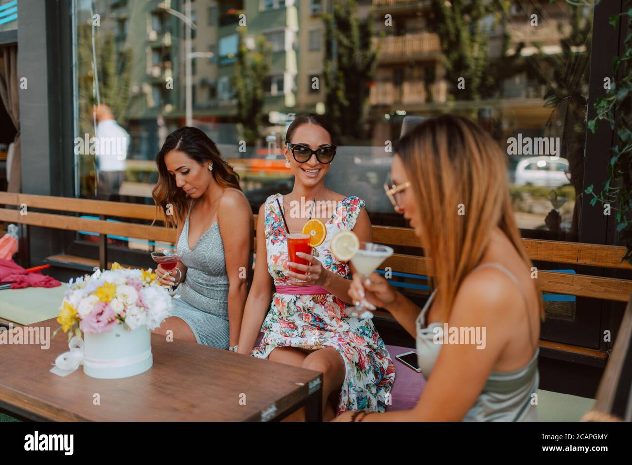 Three beautiful young caucasian women in short summer dresses are ...