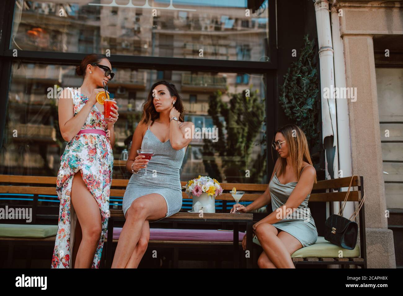 Three beautiful young caucasian women in short summer dresses are ...