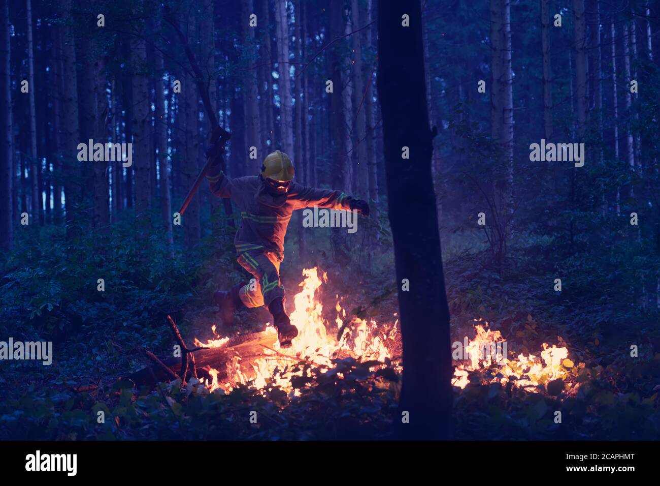 firefighter hero in action danger jumping over fire flame to rescue and ...