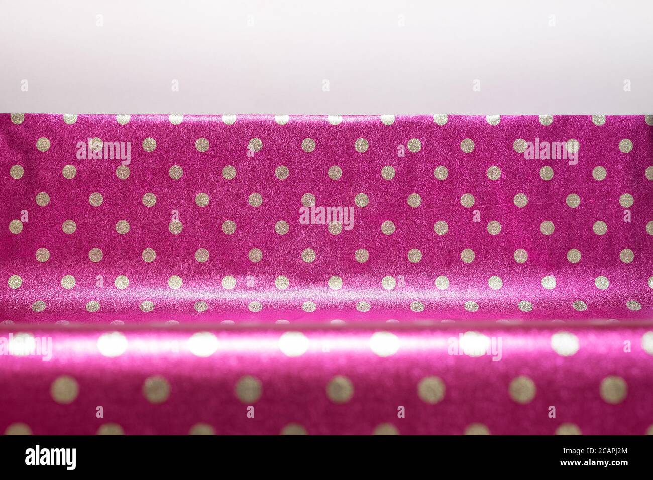 Raspberry shiny wrapping paper with polka dots with a fold. Foil for ...