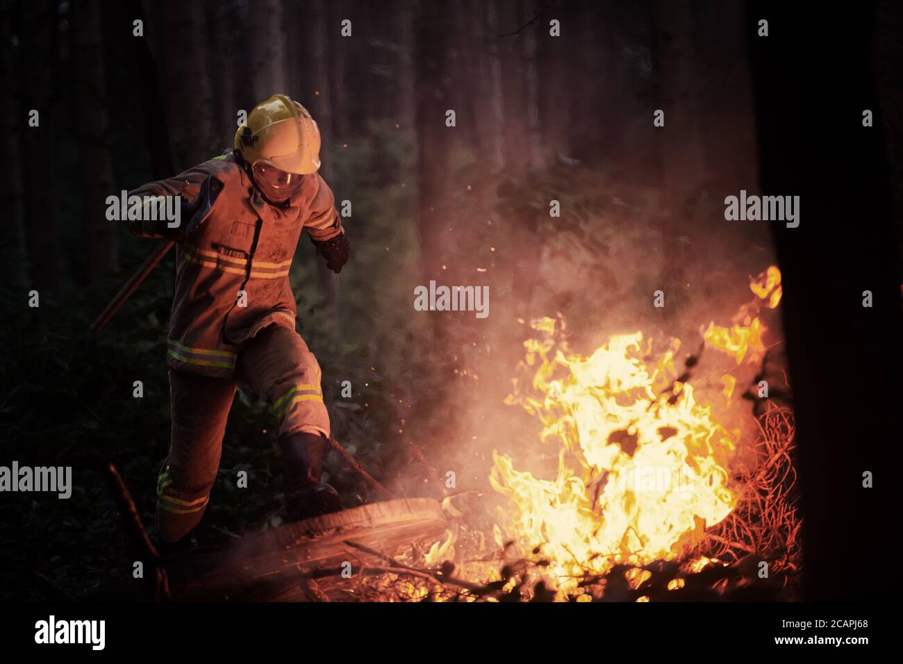 firefighter hero in action danger jumping over fire flame to rescue and ...