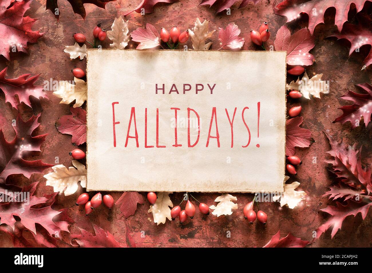 Text Happy Fallidays on aged paper page. Dark red and brown Fall frame ...