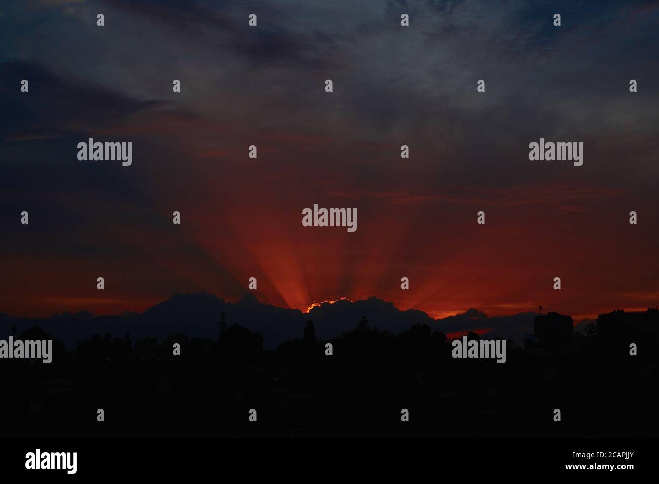 red sunset through clouds on the blue sky horizontally Stock Photo - Alamy