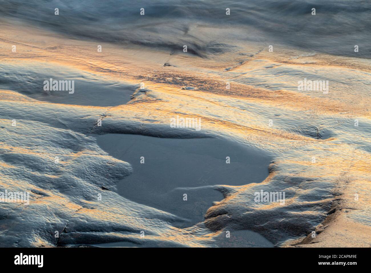 Wave -polished granite along Lake Superior shore at sunset, Neys ...