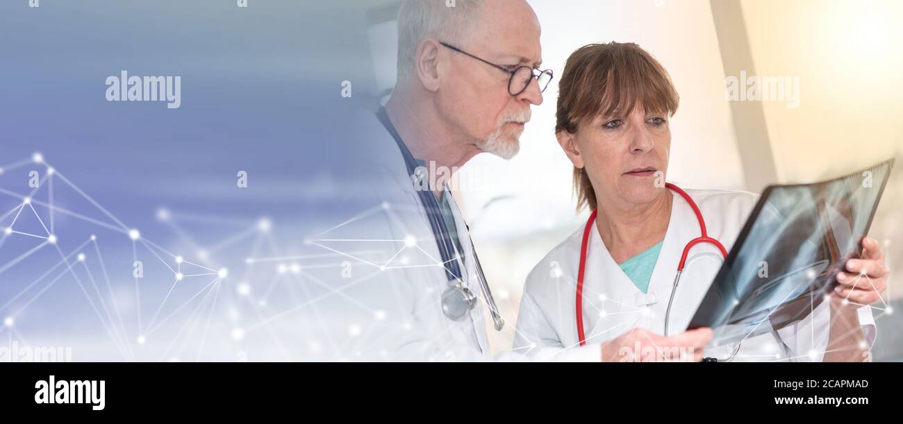 Two doctors examining x-ray report in medical office; panoramic banner ...