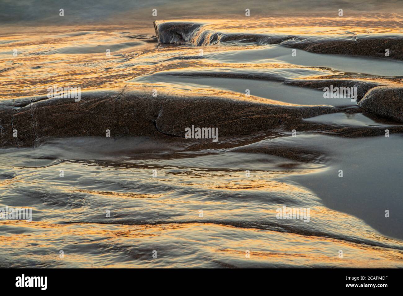 Wave -polished granite along Lake Superior shore at sunset, Neys ...