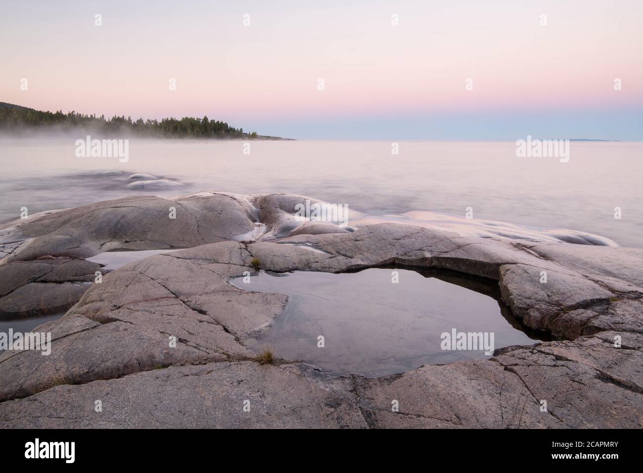 Wave polished rock outcrop at the shore of Lake Superior before dawn ...
