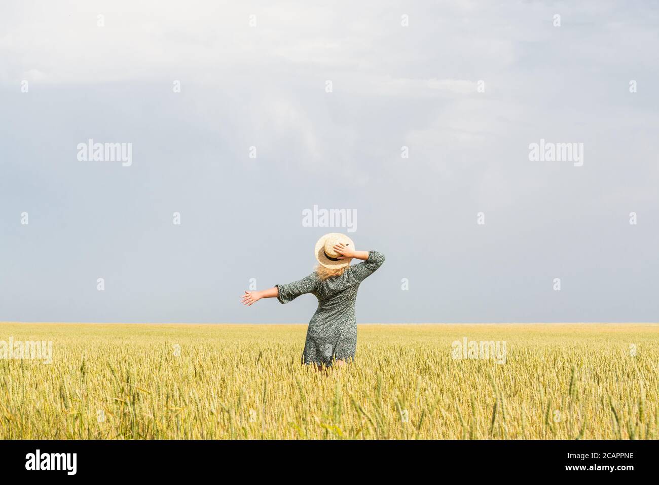 Woman in straw hat walking through the rye field on summer day Stock ...
