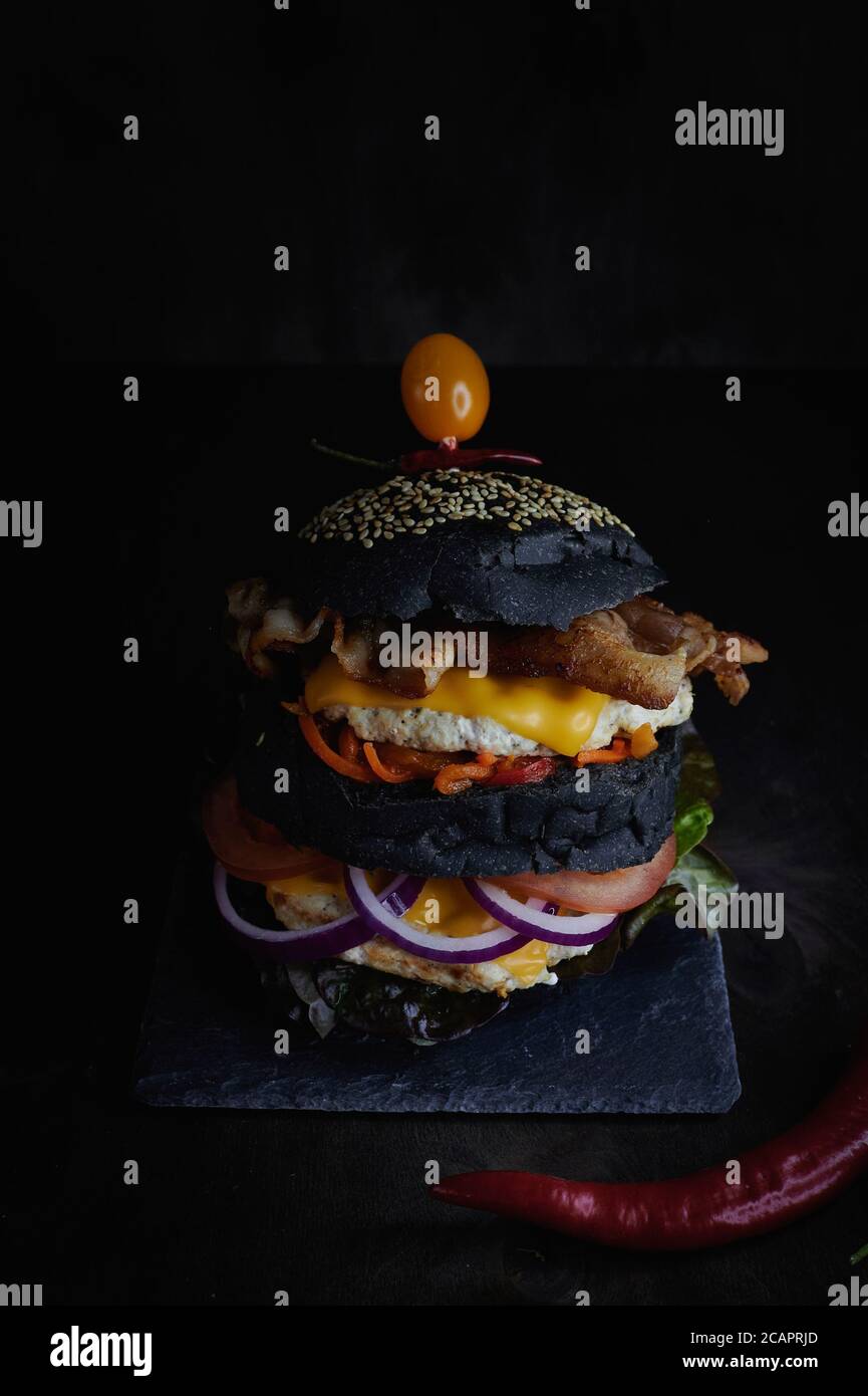 Delicious burger on a dark background filmed vertically Stock Photo - Alamy