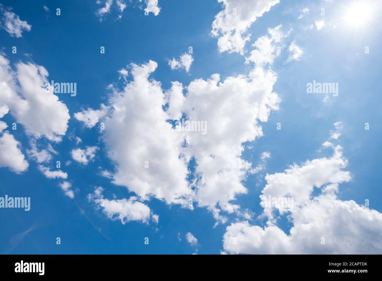 blue sky with clouds and sun, photographed upwards for backgrounds ...