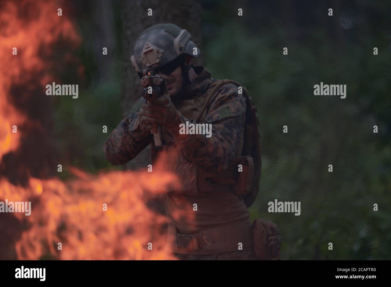 modern warfare soldier in action aiming at weapon laser sight optics in ...