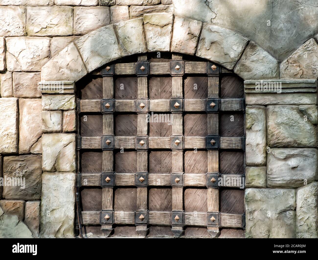 Massive old wooden gate with arch in wall made of large stones Stock ...