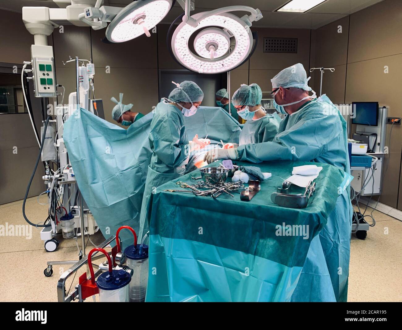 in a large operating theatre a surgical operation is performed by two ...
