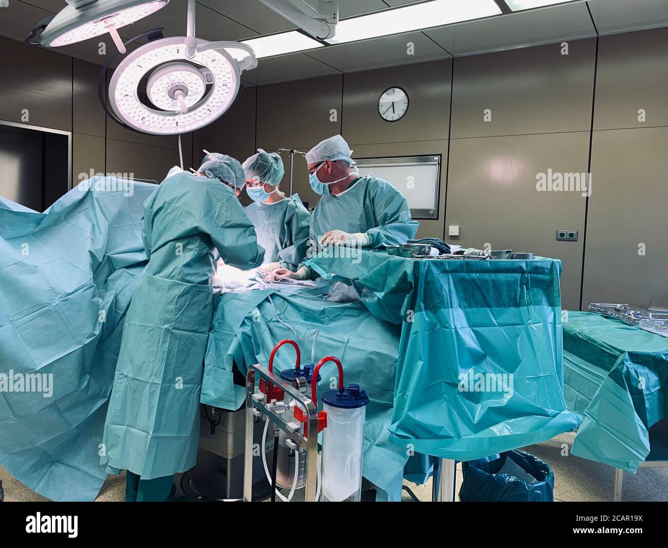 in a large operating theatre a surgical operation is performed by two ...