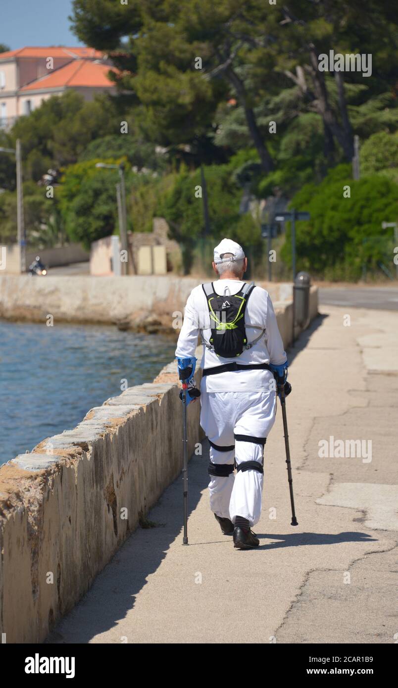 Rehabilitation through walking Leaning on two canes Stock Photo - Alamy